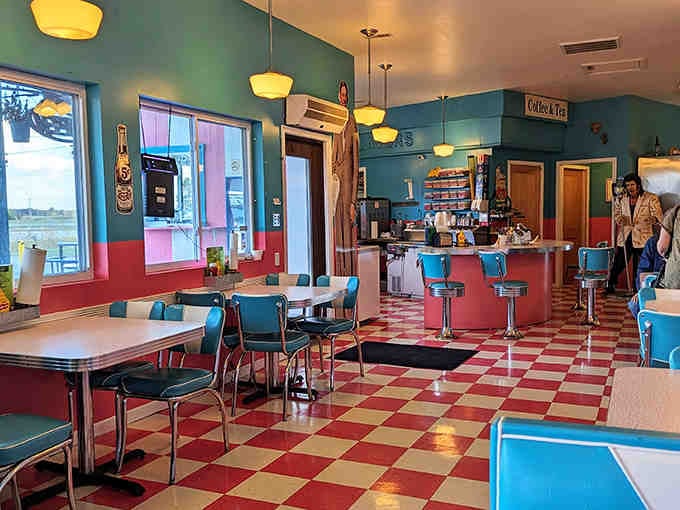 Step inside to a turquoise and pink wonderland where checkerboard floors and vintage booths transport diners straight back to the 1950s – complete with that unmistakable classic diner ambiance.