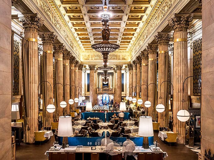 Soaring columns and gilded ceilings transform banking into dining, where your deposits now come with b&eacute;arnaise and your interest compounds with every bite.