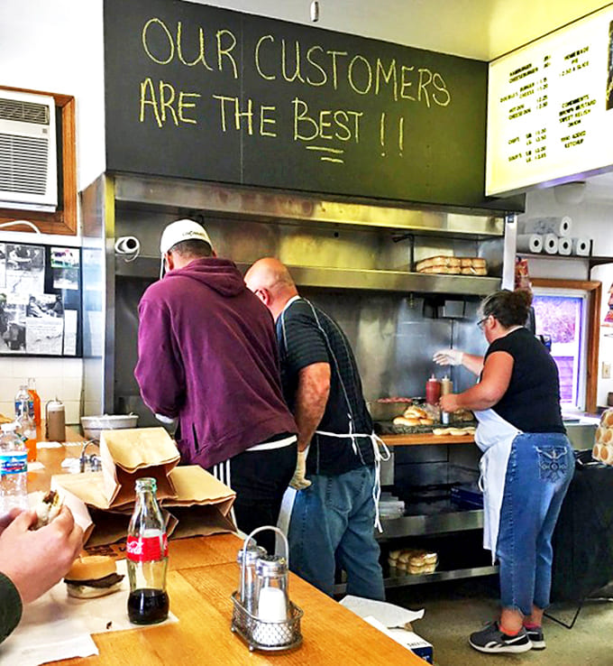 Where burger magic happens! The open kitchen at Crabill's lets you witness the artistry behind those perfect sliders while the chalkboard reminds everyone who matters most.