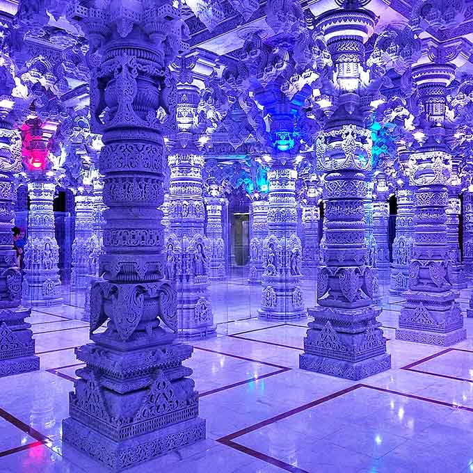 Step into this ethereal blue-lit chamber where hundreds of intricately carved pillars create an otherworldly forest of stone, each one telling ancient stories.