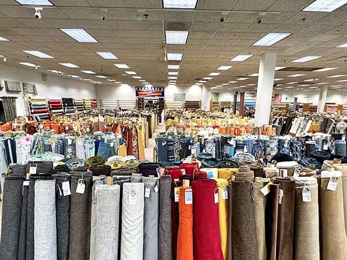 Walking into this space feels like entering Willy Wonka's factory, except instead of chocolate rivers, there are fabric rivers in every color imaginable.