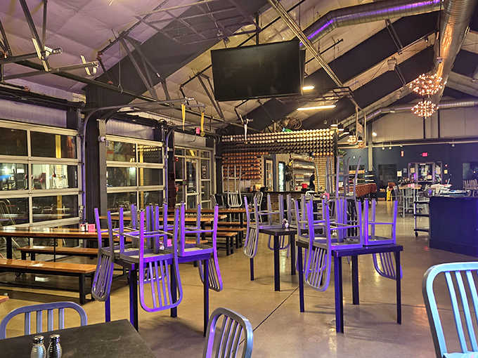Industrial-chic meets cozy gathering spot with purple chairs adding unexpected pops of color against concrete floors and exposed ductwork.