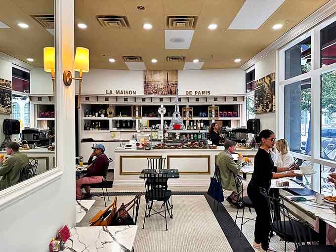 The bright, airy café interior whispers "bonjour" with its pristine counter, where "La Maison de Paris" promises authentic French delights await.