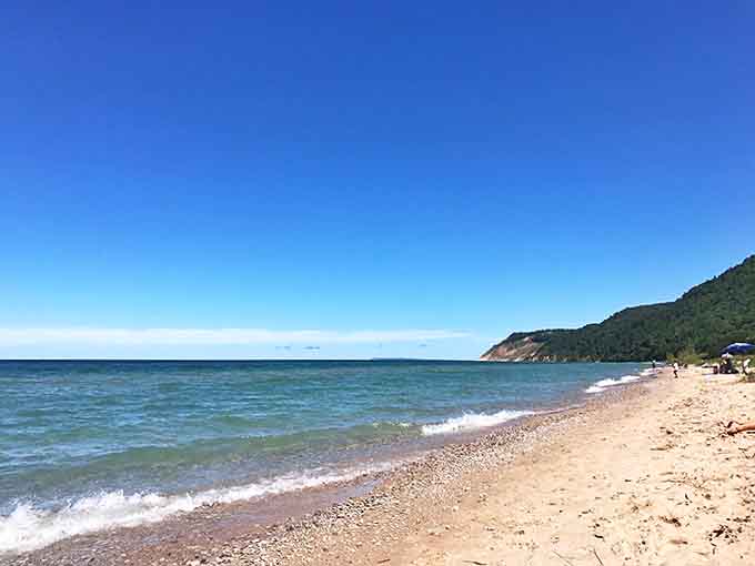 The quiet stretch of beach offers a peaceful retreat where the only soundtrack is waves gently lapping against the shore.