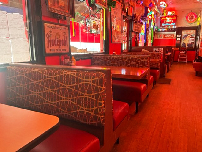 Red Booths: Vintage vinyl booths create the perfect backdrop for burger indulgence, where comfort meets nostalgia in this neon-lit dining room.