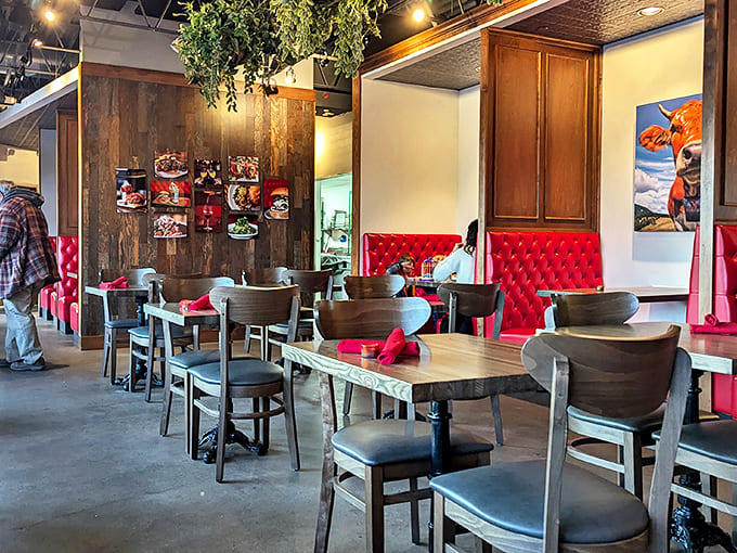 Inside, vibrant red booths pop against rustic wood paneling, creating the perfect backdrop for serious comfort food indulgence.