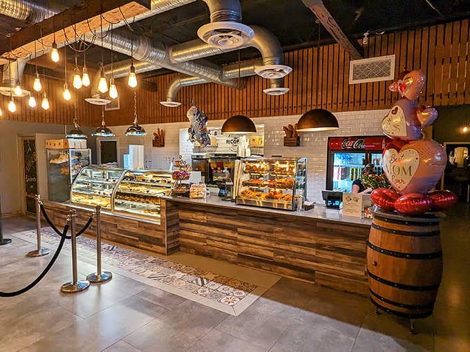 Interior: Exposed wooden beams, pendant lights, and subway tiles create a warm, inviting atmosphere where industrial meets cozy in perfect harmony.