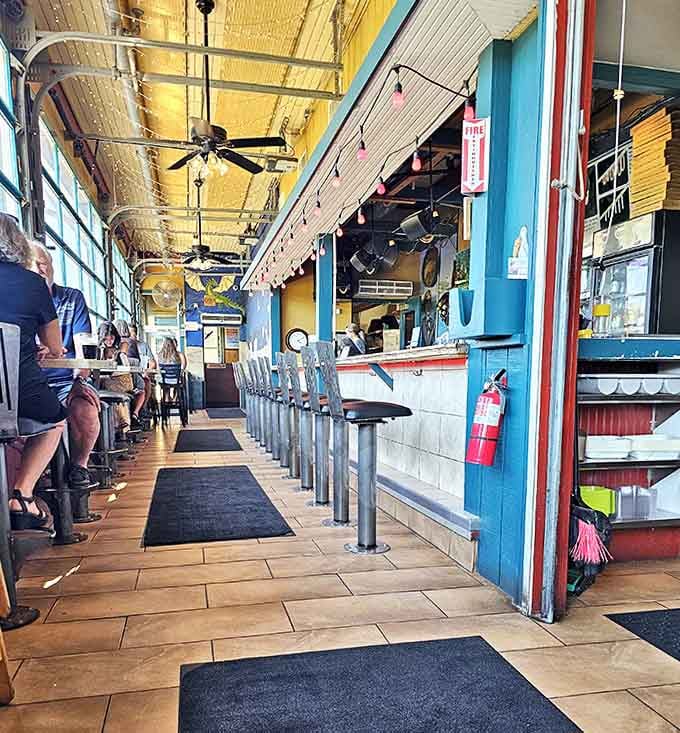 Inside, the long counter and high ceilings preserve the station's character while bar seating invites diners to watch pizza artistry in action.