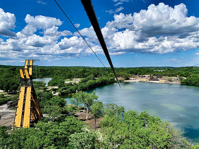 From this height, the quarry lake below resembles a mirror reflecting both sky and your newfound courage.