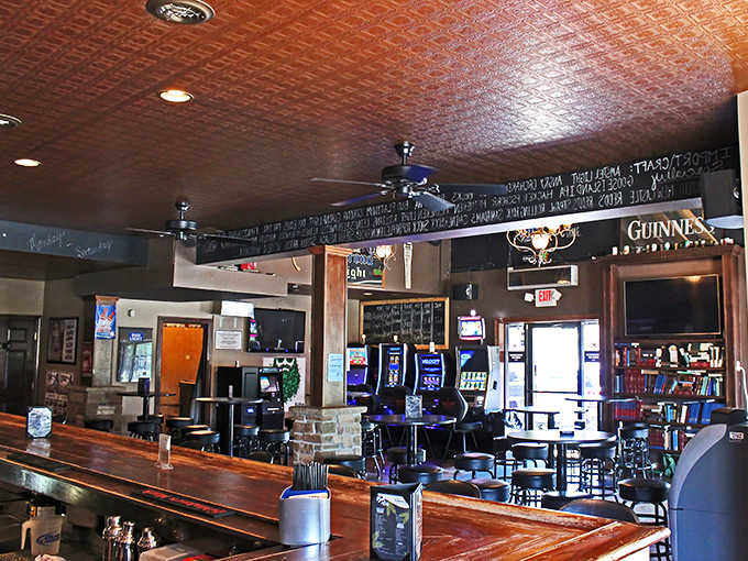Interior magic unfolds beneath a vintage tin ceiling, where wood, stone, and ambient lighting create the perfect backdrop for literary libations.