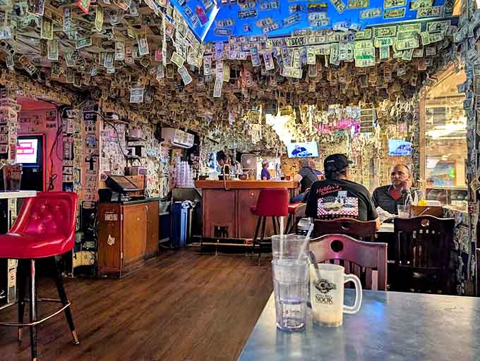 Dollar bills carpet every surface like edible wallpaper, creating a tapestry of memories from decades of satisfied burger enthusiasts.