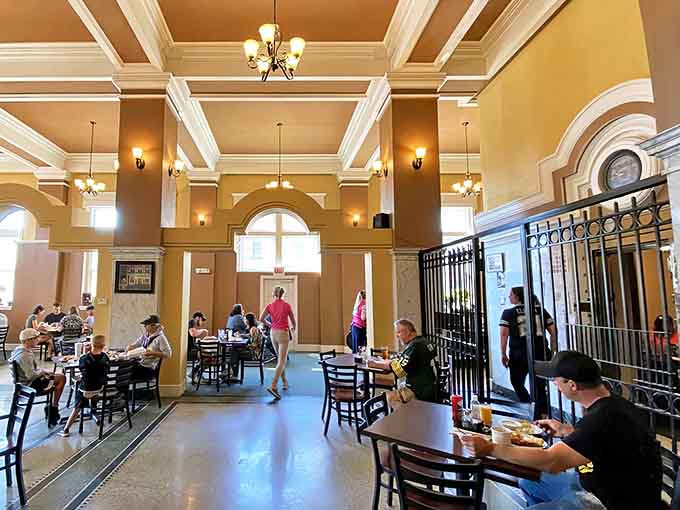 Soaring ceilings and warm golden walls transform banking business into breakfast bliss, proving architecture can age like fine wine instead of milk.