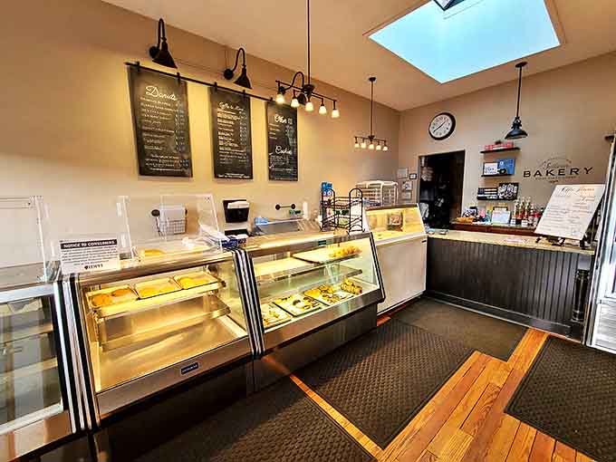 Sunlight streams through the skylight, illuminating a bakery interior that feels like stepping into a warm hug of butter and sugar.
