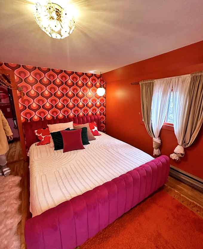 The bedroom doesn't just say "sweet dreams" &ndash; it screams it with retro wallpaper and a hot pink tufted bed that makes sleeping feel like a glamorous 1970s affair.