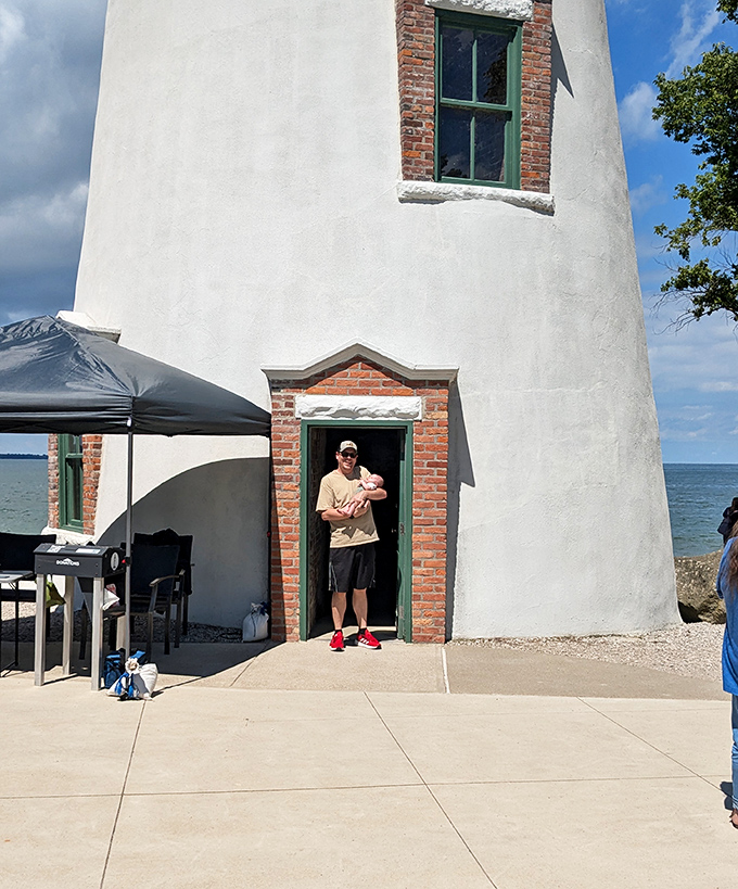 A visitor pauses in the lighthouse doorway, framed by historic brick and mortar – each step inside is a journey through two centuries of maritime history.