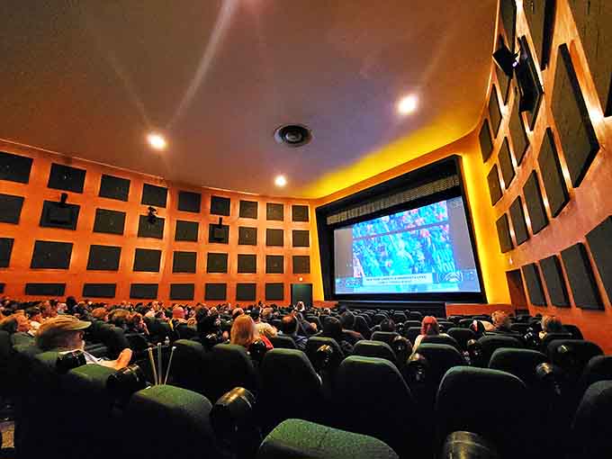 Orange-hued walls embrace moviegoers in a warm glow, creating an atmosphere where watching films feels like a communal ritual again.