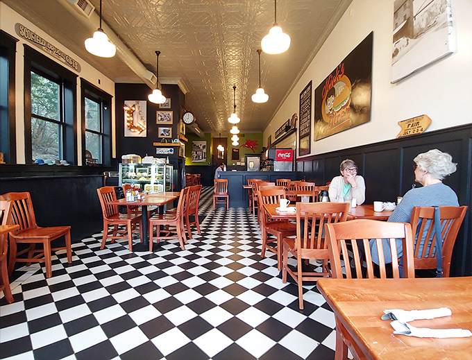 Classic black and white checkered floors meet warm wooden furnishings in this nostalgic space where time seems to slow down deliciously.