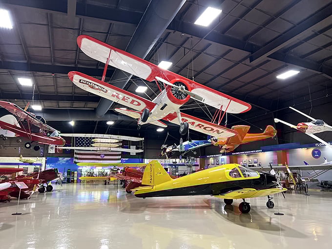 Inside, it's an aviation wonderland where planes don't just sit—they soar from the ceiling. That classic red biplane looks ready to buzz the tower at any moment.