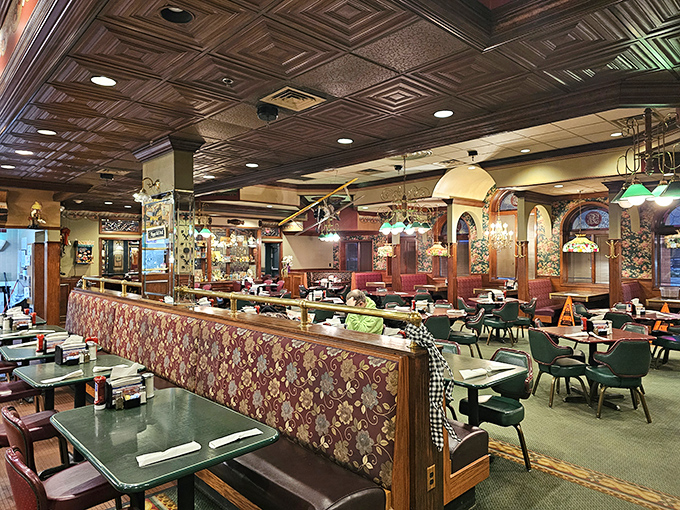 Interior view showcasing the restaurant's ornate tin ceiling, rich wood paneling, and cozy booth seating that invites lingering conversations.