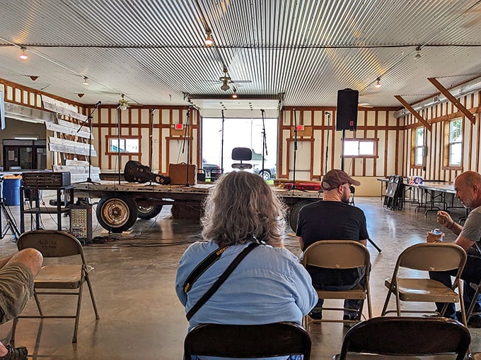 Inside the community hall, wooden chairs await history enthusiasts while a vintage flatbed wagon serves as an impromptu stage.