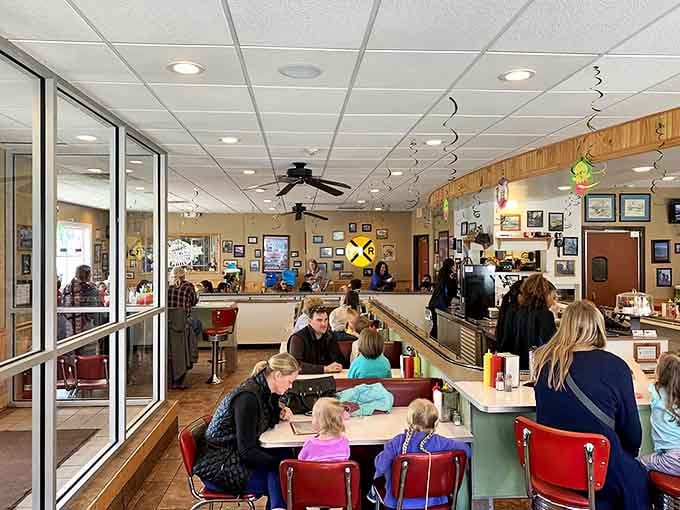 Classic diner booths meet railroad nostalgia in a space where overhead tracks hint at the magic about to unfold before your eyes.