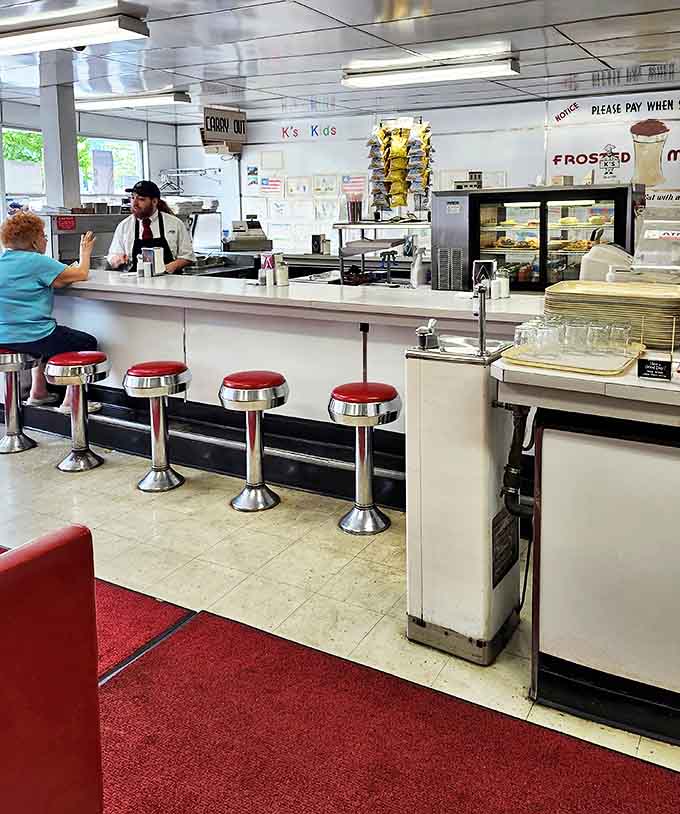 Classic counter seating where strangers become temporary neighbors, sharing nothing but appreciation for what's about to arrive on those simple white plates.