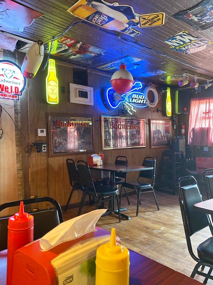 Neon beer signs illuminate the wood-paneled interior, creating the perfect ambiance for serious burger business.