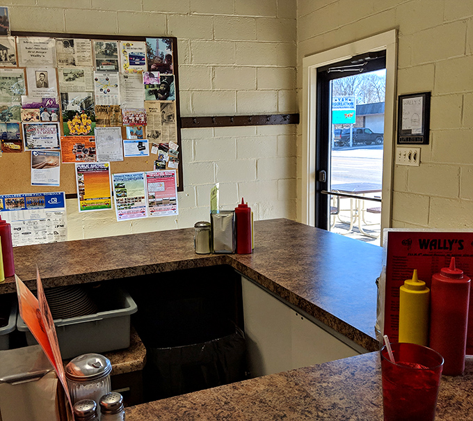 Inside Wally's, the community bulletin board tells stories of local life while condiment stations stand ready for burger perfection.