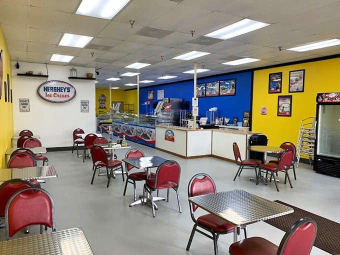 Bright yellow and blue walls create an energetic backdrop for ice cream adventures, while those red chairs wait patiently for customers ready to slow down and savor.