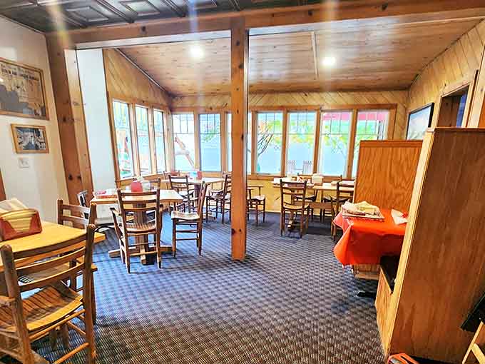 Sunlight streams through windows in this cozy dining room, where wooden beams and simple furnishings create the perfect backdrop for ice cream memories.