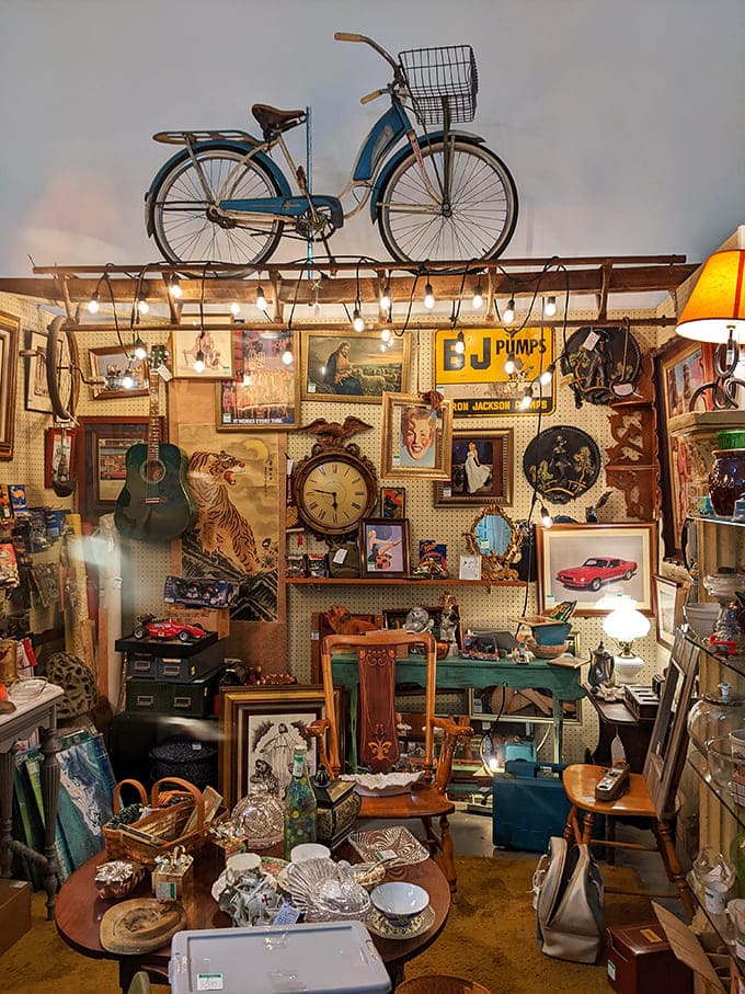 A vintage bicycle perched above a booth crammed with nostalgic treasures &ndash; like someone's attic exploded into a perfectly organized chaos of collectibles and memorabilia.