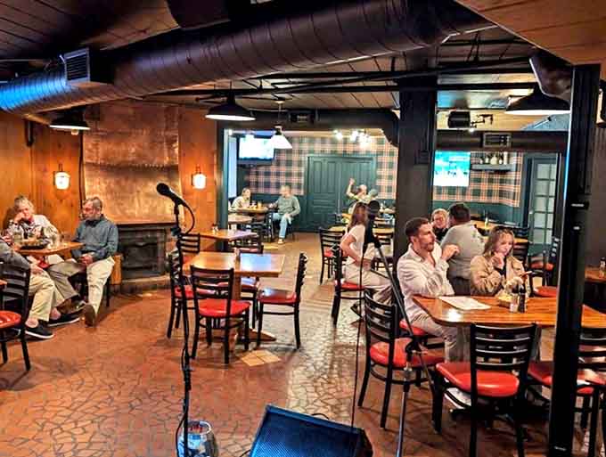 Warm wood paneling and plaid accents create a cozy retreat where conversations flow as freely as the drinks in this subterranean sanctuary.