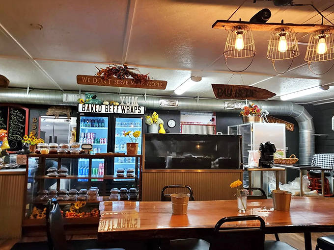 Industrial lighting casts a warm glow over the counter where barbecue dreams come true. That sign says it all: "We Don't Serve Mean People."