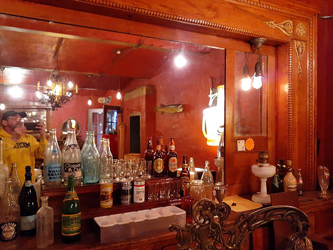 Behind the bar, vintage bottles line up like soldiers from another era, their glass catching light in ways that make you wonder what stories they could tell.