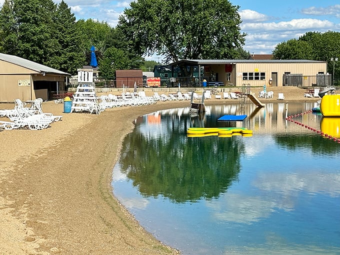 Sandy shores meet crystal waters at this beach area, where lounge chairs await sunbathers while inflatable fun beckons offshore.