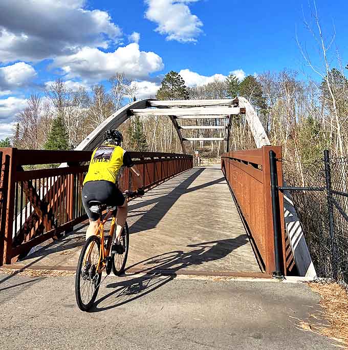 Pedal power in motion! This cyclist tackles one of the trail's iconic bridges, where engineering marvel meets natural splendor.