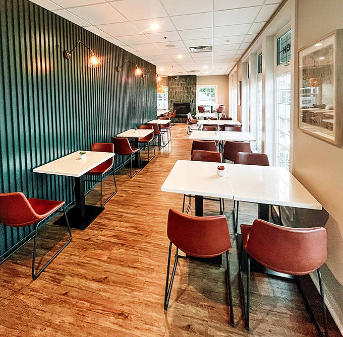 Modern meets cozy inside with teal corrugated walls, warm wooden floors, and strategically placed lighting creating the perfect atmosphere for lingering conversations.