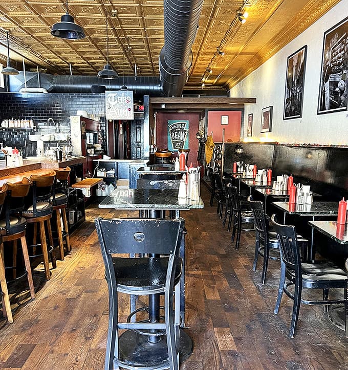 Warm burgundy walls, pressed tin ceilings, and wooden furnishings create an atmosphere that's both cozy and inviting.