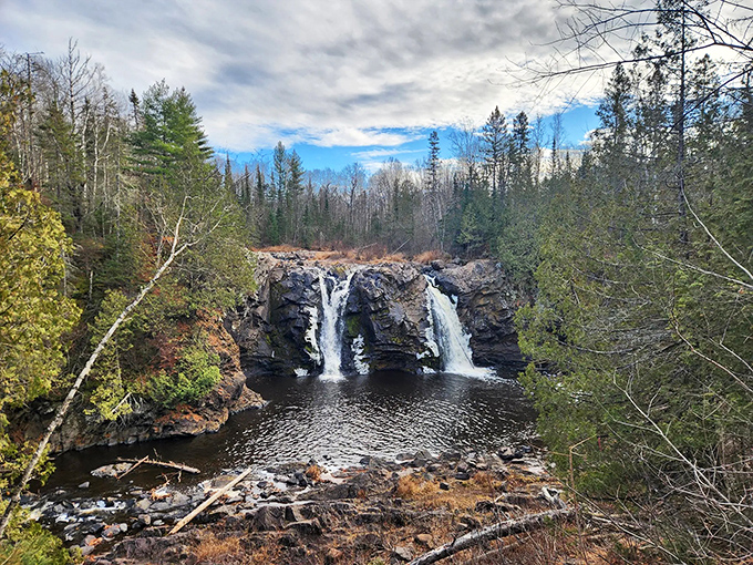 Big Manitou Falls plunges dramatically between dark rock walls, creating Wisconsin's tallest waterfall and a misty microclimate for ferns and mosses.