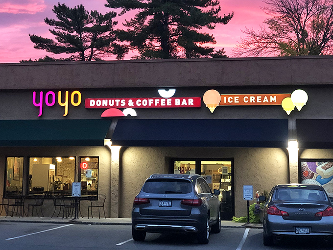 YoYo Donuts glows with inviting light at dusk, its colorful sign beckoning sweet-toothed visitors like a dessert lighthouse.