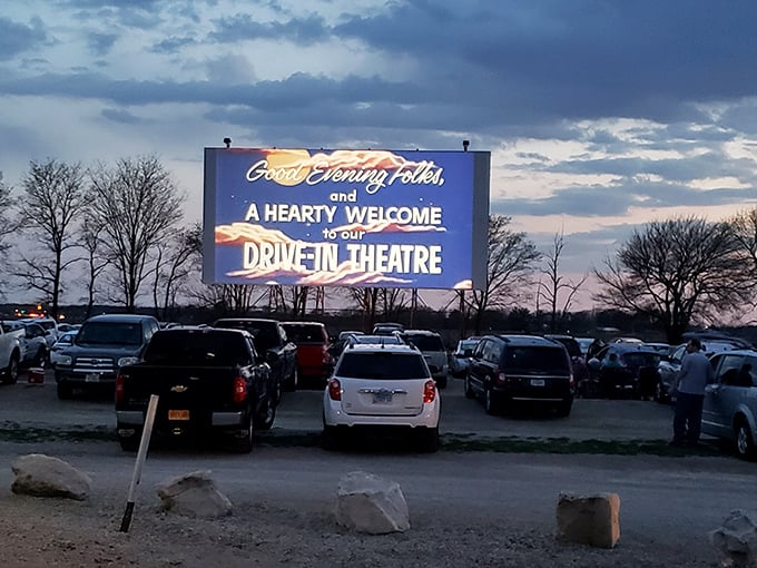 As twilight settles over the drive-in, cars gather beneath the welcoming screen that greets visitors with old-fashioned hospitality and the promise of cinematic adventures.