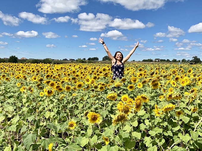 Pure joy radiates from this visitor surrounded by Thompson Farm's endless sea of sunflowers &ndash; nature's ultimate mood-booster captured in one perfect moment.