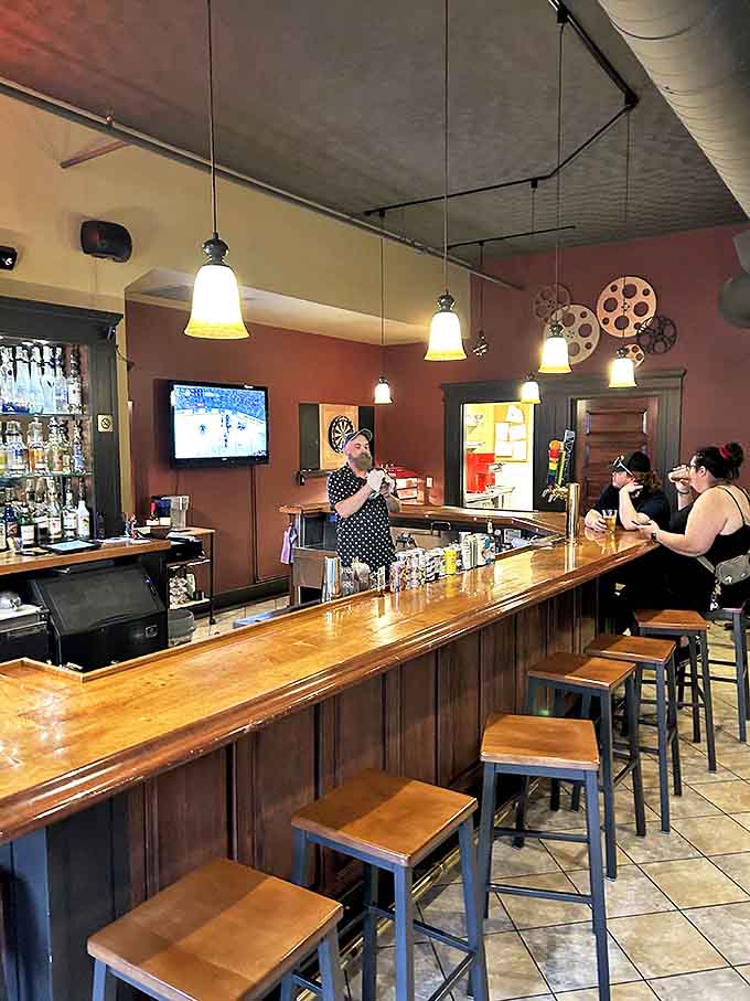 The welcoming bar counter invites conversation and craft cocktails, with pendant lighting casting a warm glow over the polished wood surface.