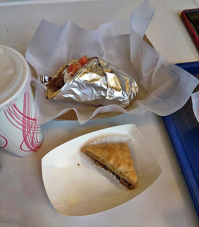 Wrapped in foil and nestled in paper, this gyro isn't just lunch &ndash; it's a handheld masterpiece of seasoned meat, fresh veggies, and creamy tzatziki that demands a moment of silence.