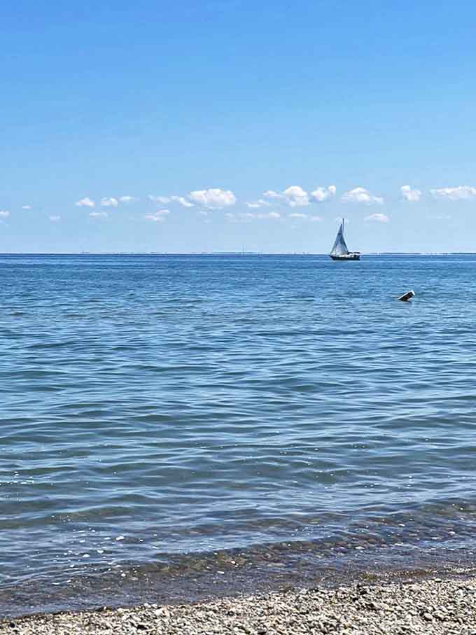Sailboats dot the horizon like tiny paper cutouts against the vast blue canvas of Lake Huron, nature's perfect minimalist painting.