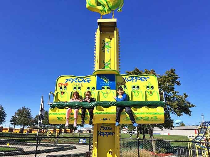 Kids squeal with delight on the Frog Hopper, their expressions capturing that perfect moment between excitement and "am I going too high?"