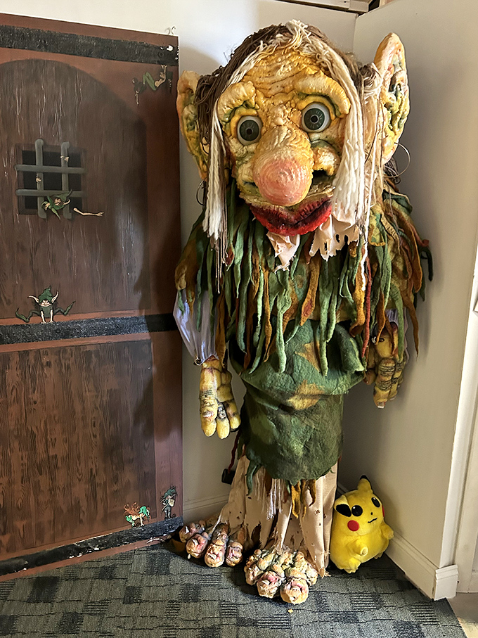 This isn't your childhood troll doll! A massive troll figure looms ominously in the corner, its textured skin and bulging eyes suggesting it might actually demand tolls from passersby.