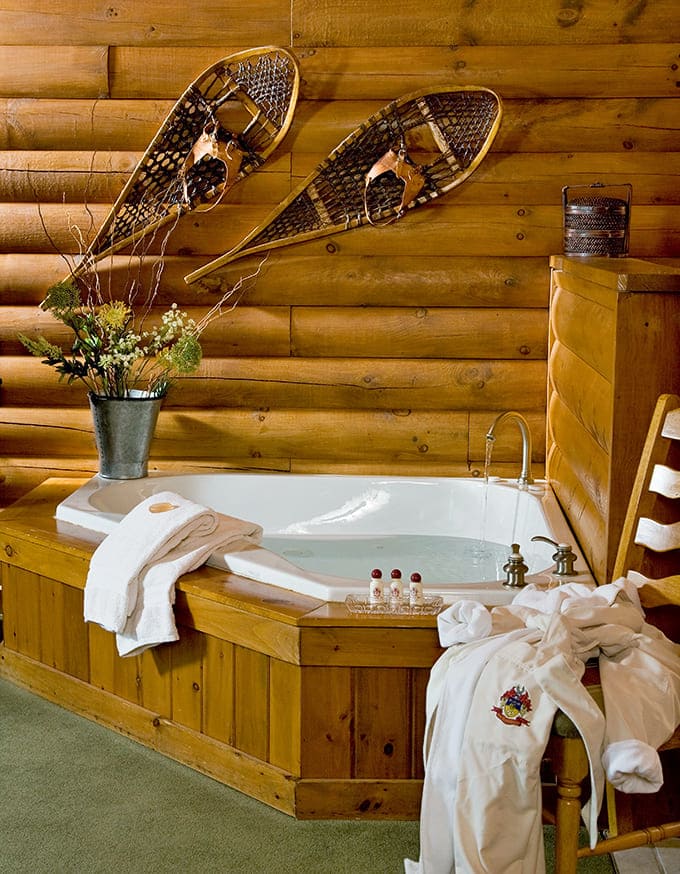 Vintage snowshoes adorn log walls above a soaking tub &ndash; because nothing says "adventure meets relaxation" quite like bathroom sporting equipment.