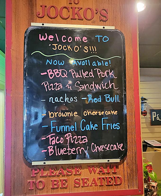That chalkboard menu is basically a roadmap to happiness, featuring everything from BBQ pulled pork to funnel cake fries.