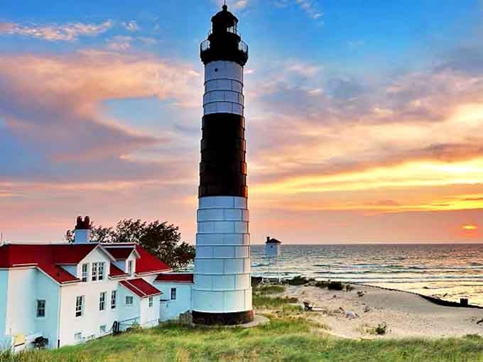 The Big Sable Point Lighthouse stands tall against a painted sunset, nature's daily masterpiece that locals never take for granted.